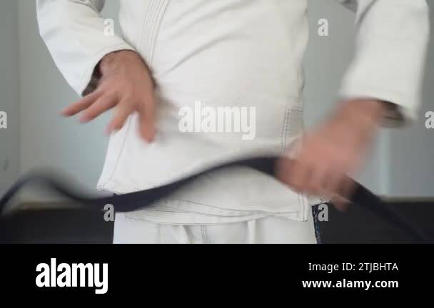 Close up on midsection of the bjj brazilian jiu jitsu black belt hands ...