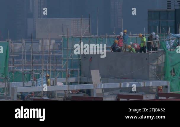 Builders On The Roof Of A High-Rise Building Under Construction In Hong ...