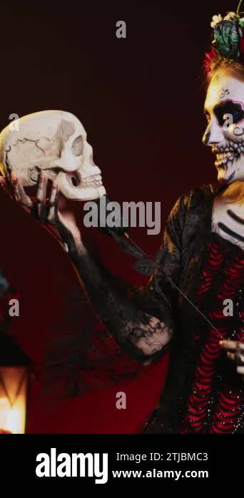 Vertical video: Horror female model acting flirty with skull and black ...