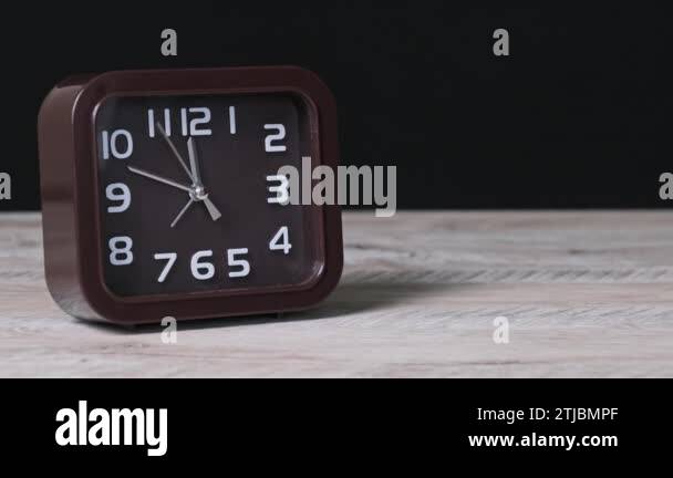 Analog clock on wooden table and black background show time. The second ...