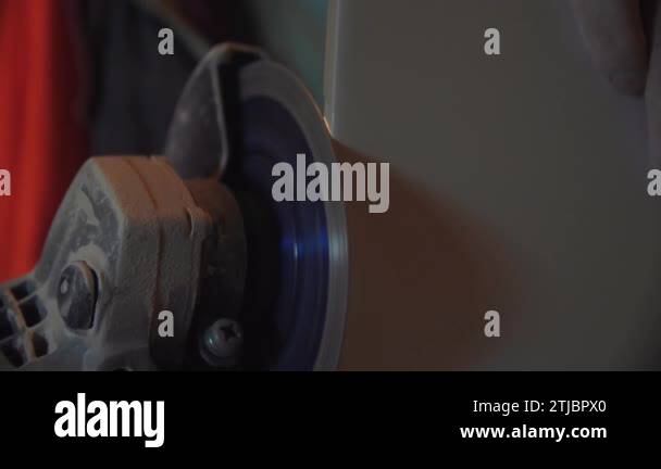 Grinding ceramic tile edge with disk saw in workshop closeup. Preparing ...