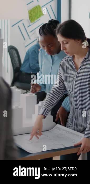 Vertical Video Multi Ethnic Women Analyzing Building Model And