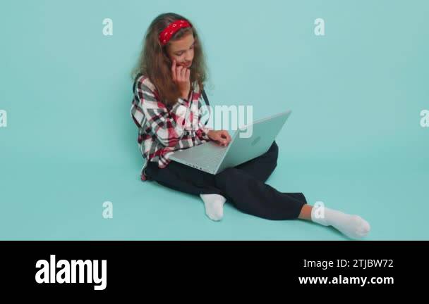 Happy young teenager child girl kid 12 years old works on notebook ...