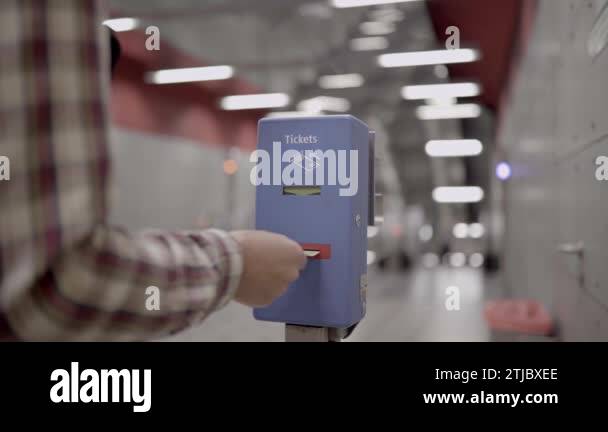 Passenger inserts ticket into validator to mark the time. Munich metro ...