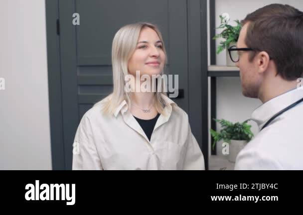 Professional male doctor otolaryngologist doing nose examination with otoscope in modern ...