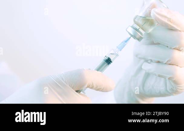 Family medicine. The doctor holds a syringe and a bottle with a vaccine ...