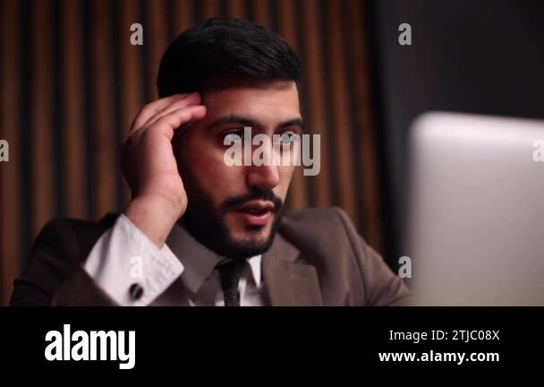 Tired man behind a computer screen from boring routine work in the ...