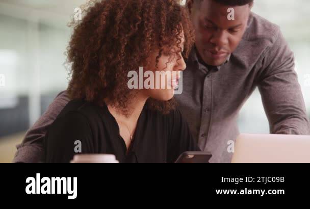 Young African American millennials working in an office using a mobile ...