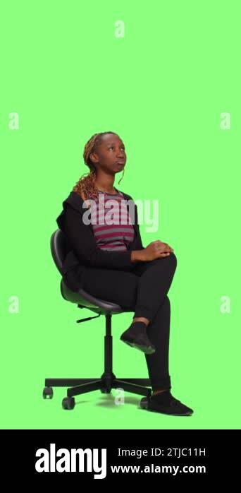 Vertical video: African american woman waiting on chair over full body ...