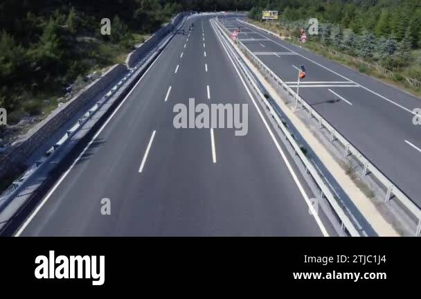 Drone footage of two racing motorcycles speeding on a straight highway ...