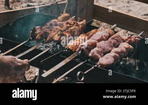 Grilling shashlik on barbecue grill outdoors. Process of cooking ...