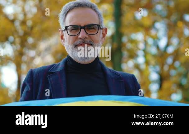 Caucasian middle-aged man with grey hair and beard wearing glasses ...
