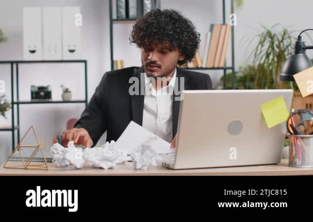 Angry furious indian man working at office throwing crumpled paper ...