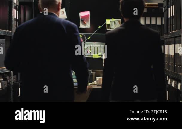 Police agents working together on case, evaluating forensic evidence ...