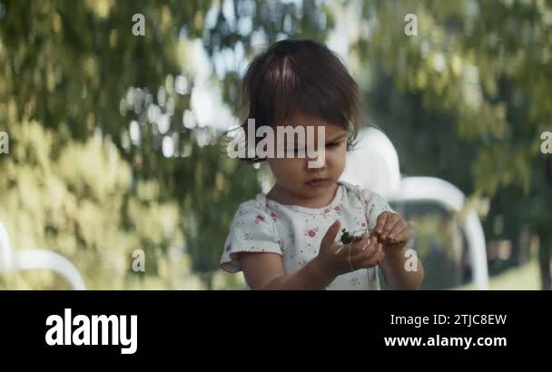 Cute baby girl exploring a park in summer. Real life, candid footage ...