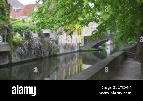 Panning out of focus background plate of walkway beside canal in Bruges ...