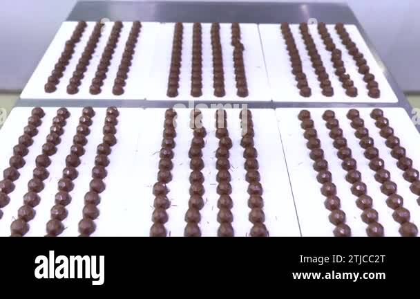 Automated Production line of chocolate pralines in a factory. Different ...