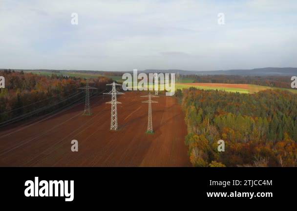 Power lines and transmission towers at countryside. Flying over high ...
