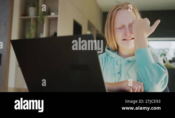 A woman calms down a teenage girl who is crying at the laptop screen ...