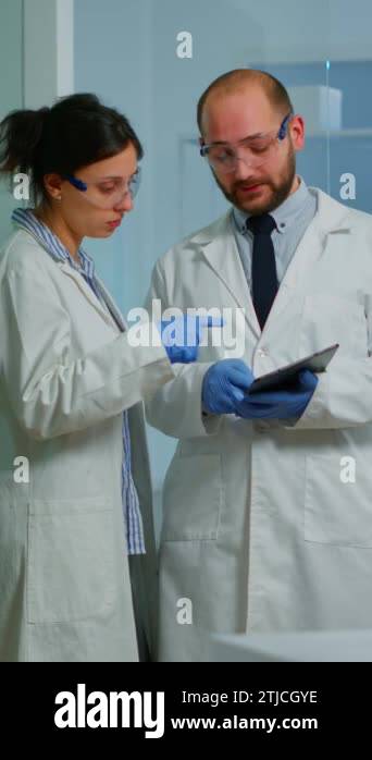 Vertical video: Chemist nurse explainig to doctor vaccine development ...