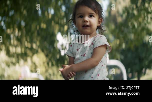 Cute baby girl exploring a park in summer. Real life, candid footage ...