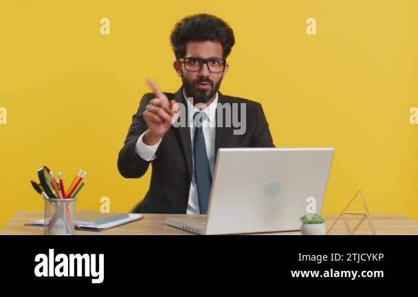 Indian businessman working on laptop shakes finger and saying No be ...