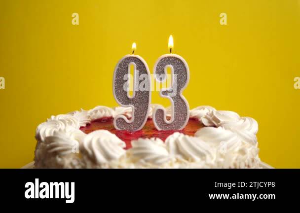A candle in the form of the number 93, stuck in a holiday cake, is ...