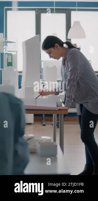 Vertical video: Woman architect designing blueprints plans with ...