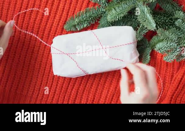 Hands of a cute girl unwrap a Christmas stollen wrapped in paper. Woman ...