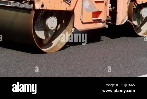 Asphalt laying. Road building asphalt paver is laying a new layer of ...