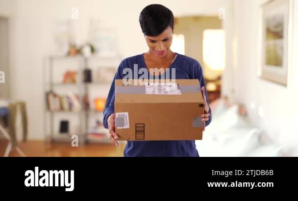 Beautiful black female shaking cardboard box excitedly, guessing what's ...