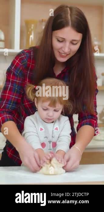 Vertical Screen: mother and daughter having fun cooking together in ...