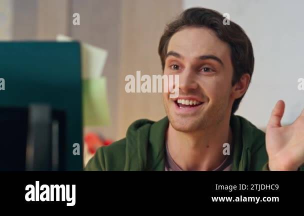 Cheerful man saying hello video calling computer at office closeup ...