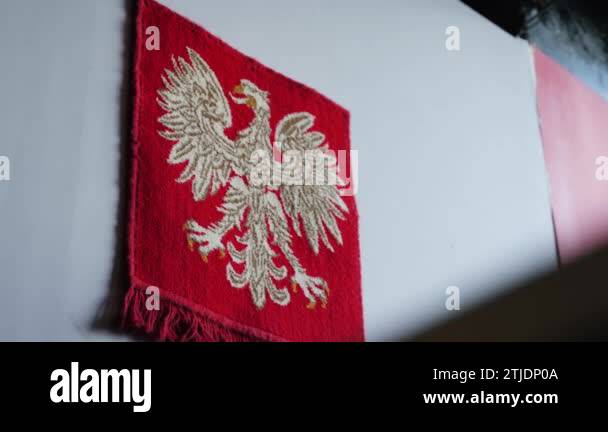 red Polish PRL emblem of white eagle without its crown hanging on white ...