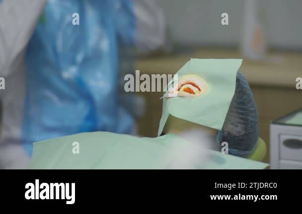 Patient in dentists office with covered face seats in dentist chair ...