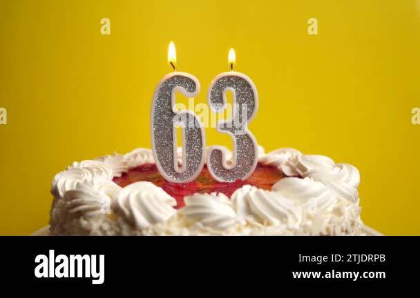 A candle in the form of the number 63, inserted into the holiday cake ...