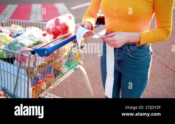 Woman checks paper check after shopping for groceries at mall by ...
