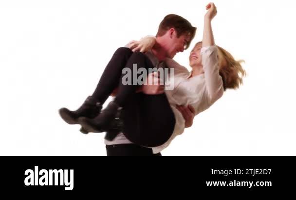 Smiling male picking up girlfriend in his arms and spinning her around ...