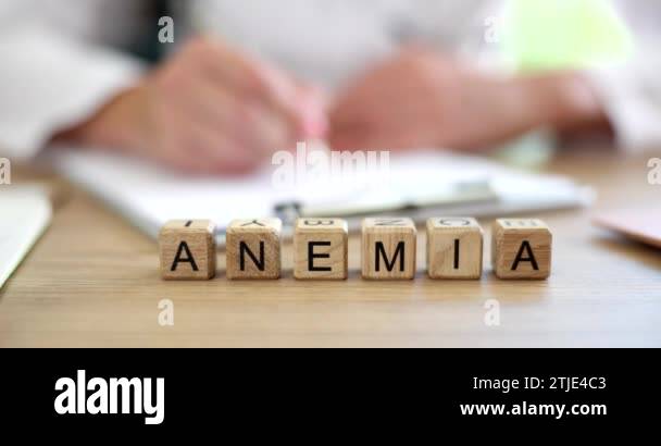 Doctor hand makes inscription anemia in document. Anemia causes ...