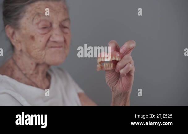 Older woman gets removable dentures, shows on camera. Concept of oral ...