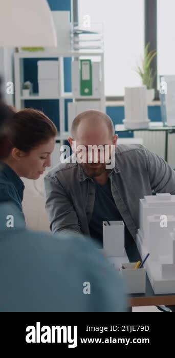 Vertical video: Colleagues doing teamwork in designing blueprints plan ...