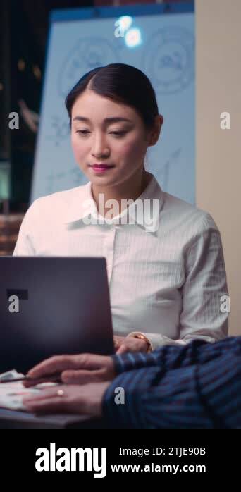 Vertical video: Smiling asian employee looking at camera in business ...