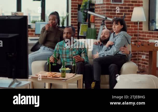 Terrified people watching scary movie on tv channel, being frightened ...