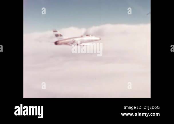 Grey fighter jet of USAF in the 1950s in flight over the clouds. Close ...