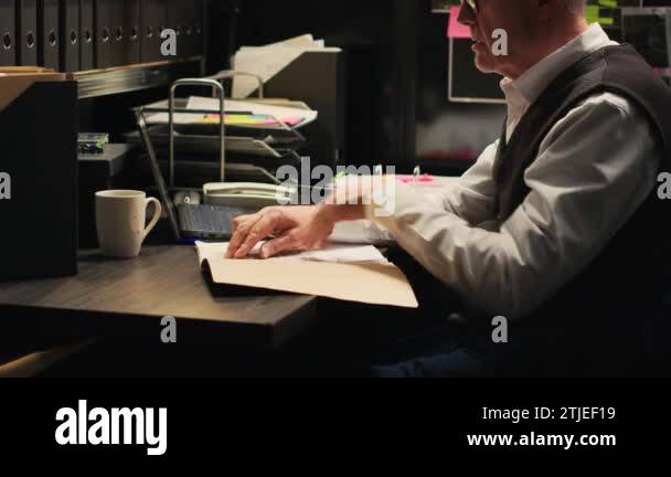 Detective reading classified records in police agency, finding new ...