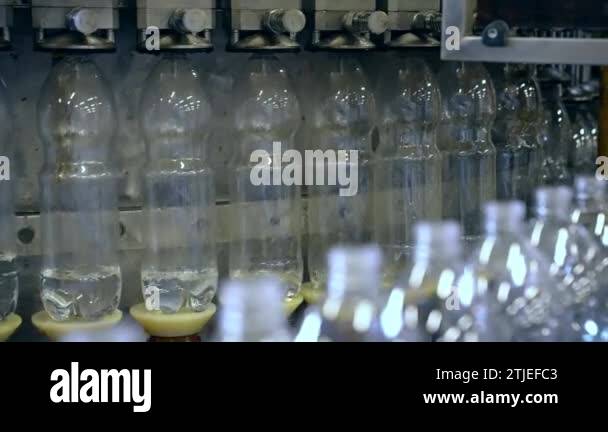 Production of drinking mineral water in plastic bottles. Close-up of ...