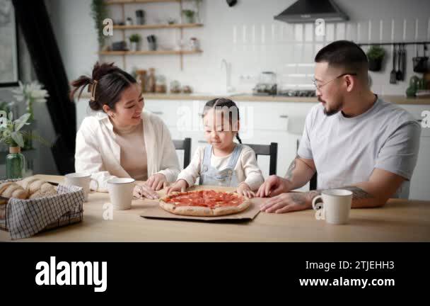 Asian Family Eating Pizza. Mom Dad and Daughter are ready to enjoy ...