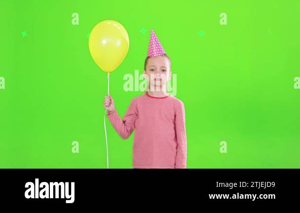 Sad, disappointed birthday girl, wearing polka dot party hat looking at ...