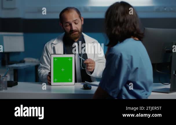 Medic holding digital device pointing at green screen chroma key ...