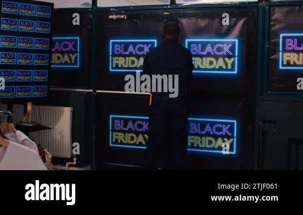 Security guard keeping people in check before opening clothing store on ...